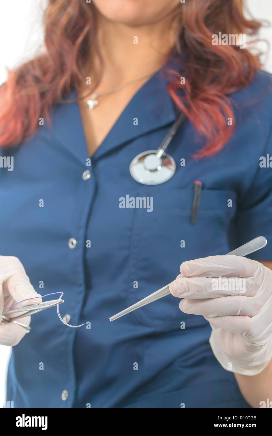 Doctor holding surgical forceps suture needle, suturing material Stock ...