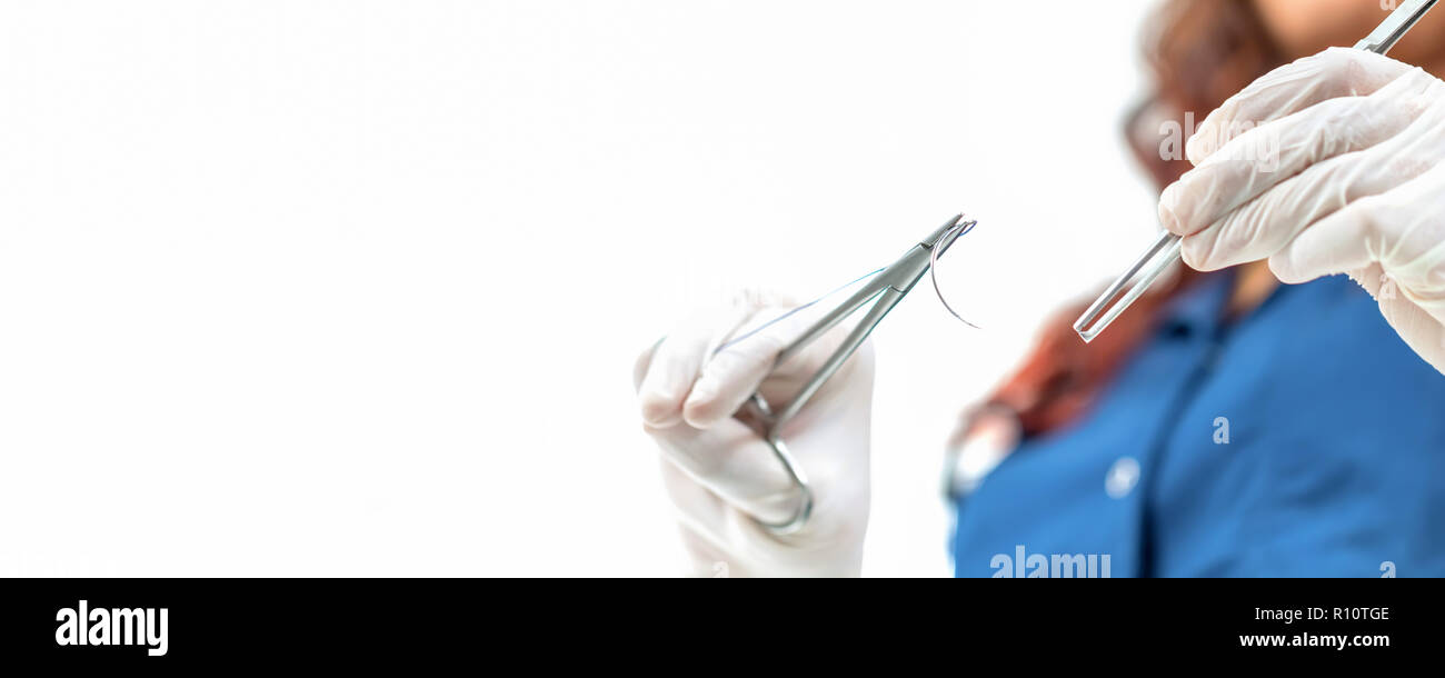 Doctor holding surgical forceps suture needle, suturing material Stock ...