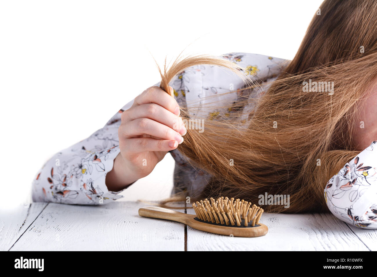 Young woman looking at split ends. Damaged long hair Stock Photo - Alamy
