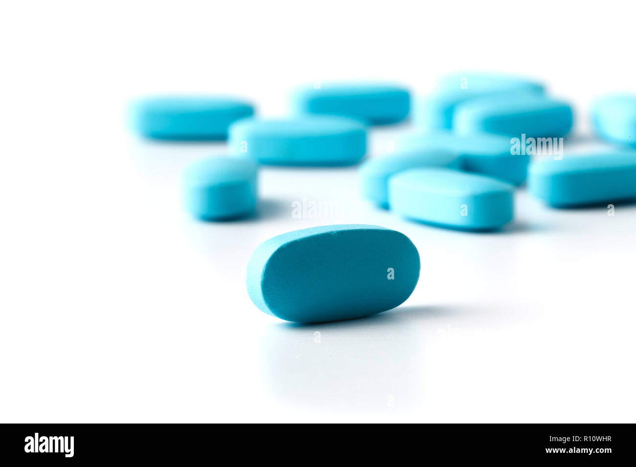 Pile of blue pills isolated on white Stock Photo - Alamy
