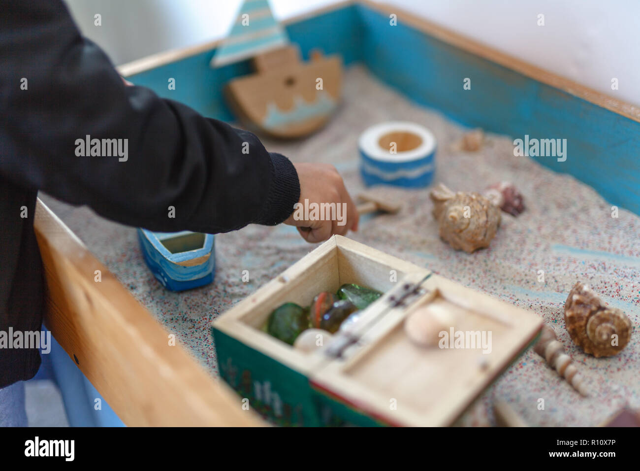 Sand therapy. The child is built in a sandbox world Stock Photo - Alamy