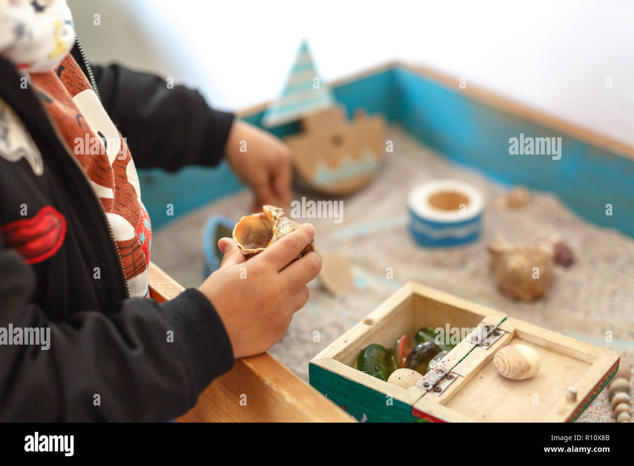 Sand therapy. The child is built in a sandbox world Stock Photo - Alamy