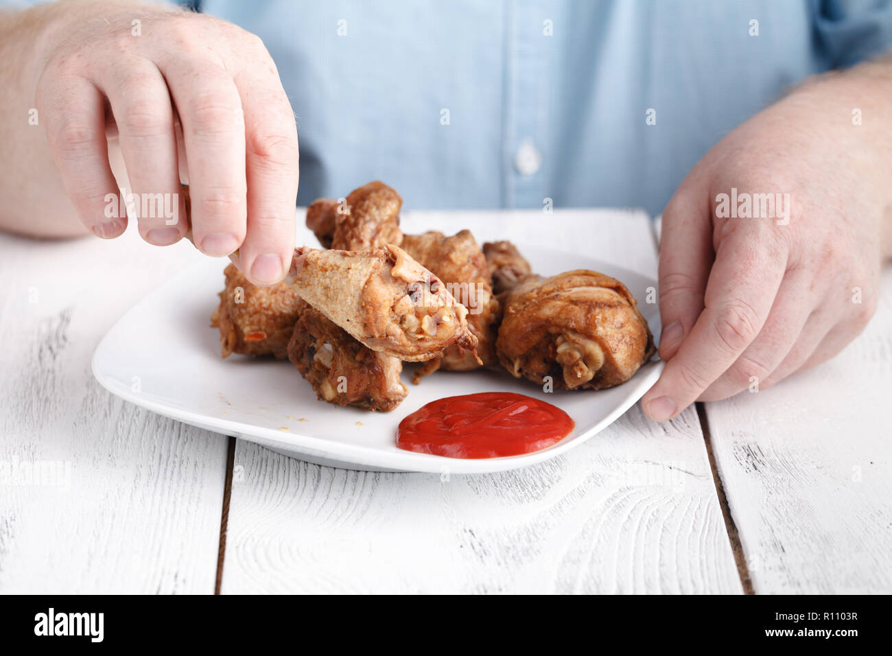 Hand holding grilled chicken wing hi-res stock photography and images ...