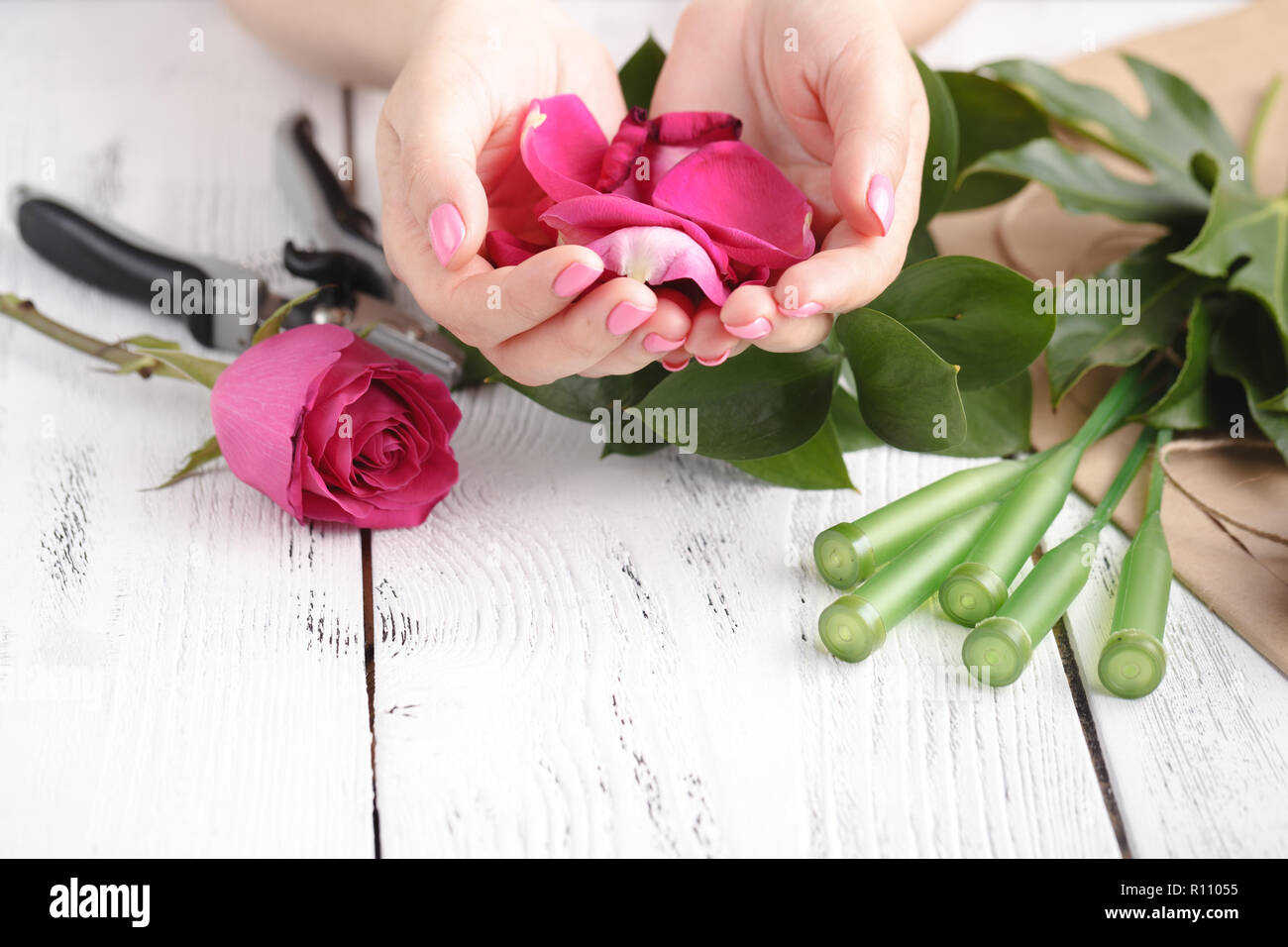 Hand of a florist woman full of rose petals for wedding Stock Photo - Alamy