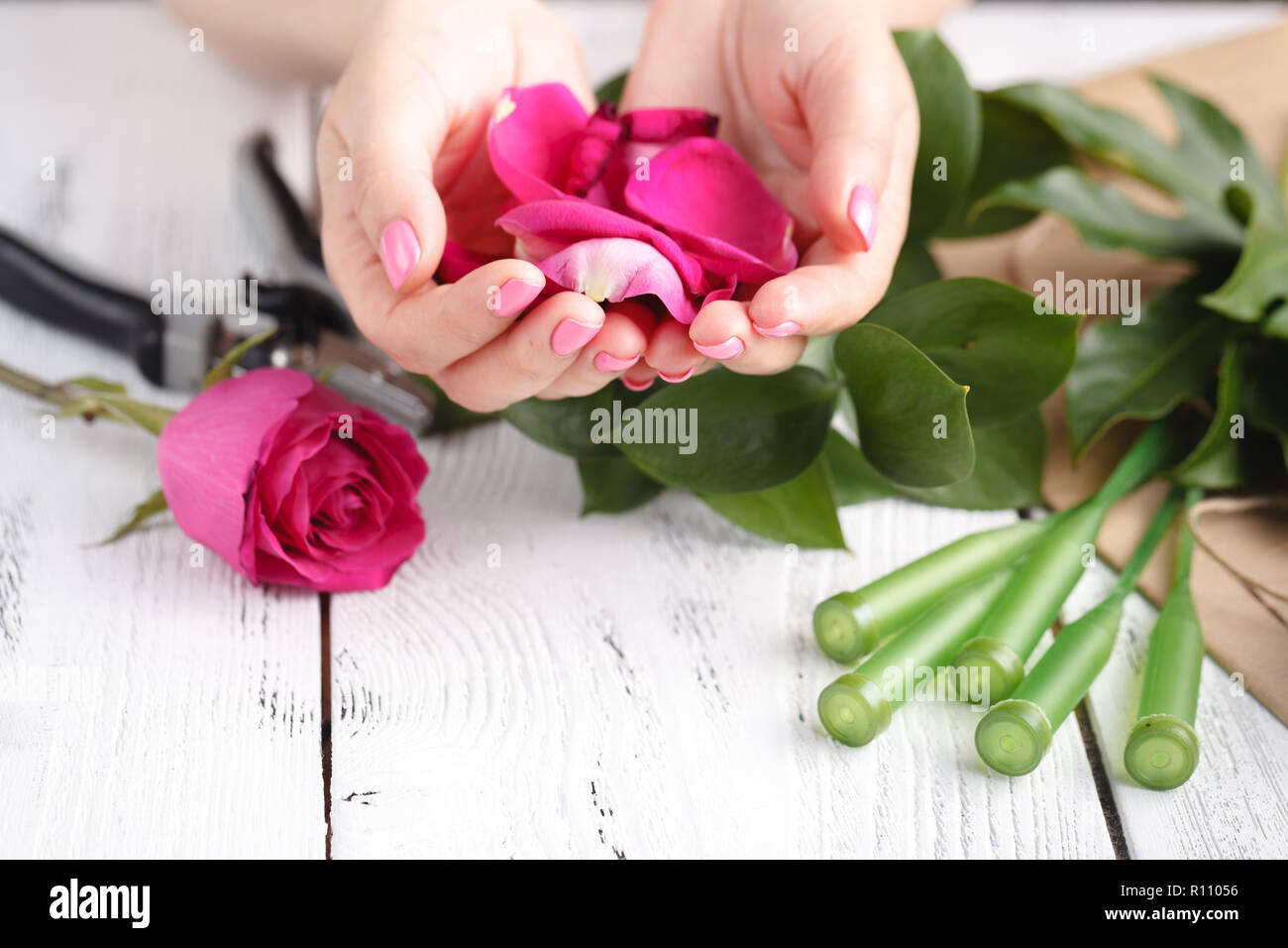 Hand of a florist woman full of rose petals for wedding Stock Photo - Alamy