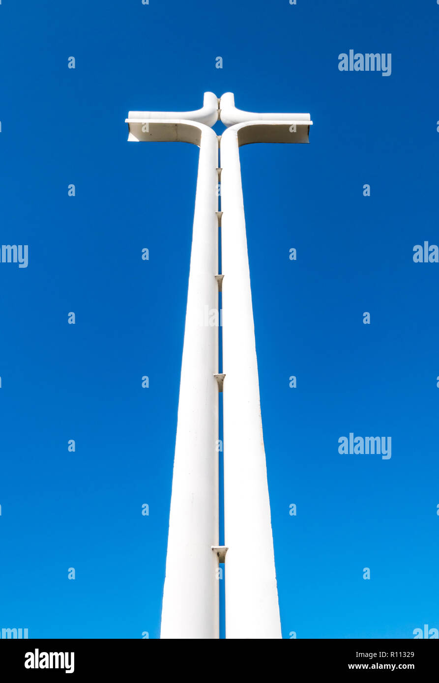 Modern iron cross of white color, isolated on a blue sky background ...