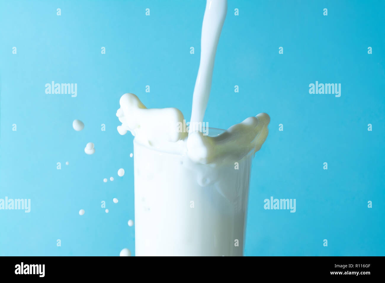 Splash of milk in the glass, pouring jet stream of milk in a glass ...