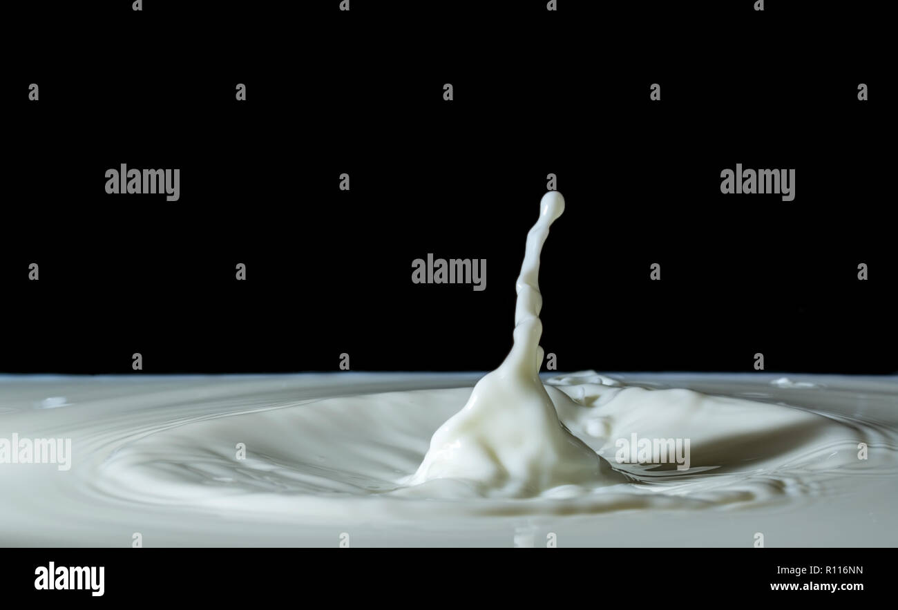 splashing milk isolated on black background Stock Photo - Alamy