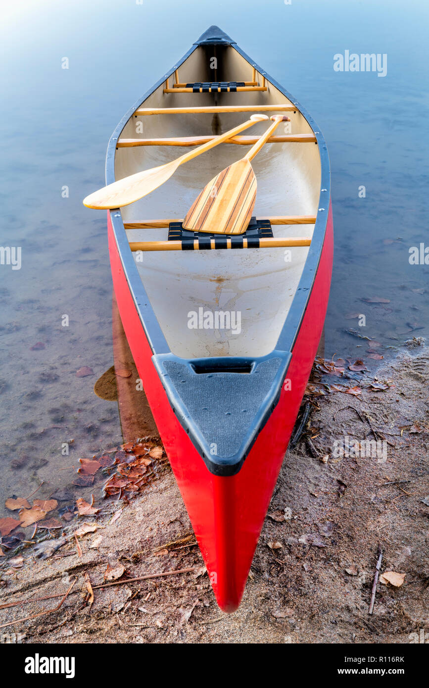 red tandem canoe with wooden paddles on a lake shore Stock Photo - Alamy