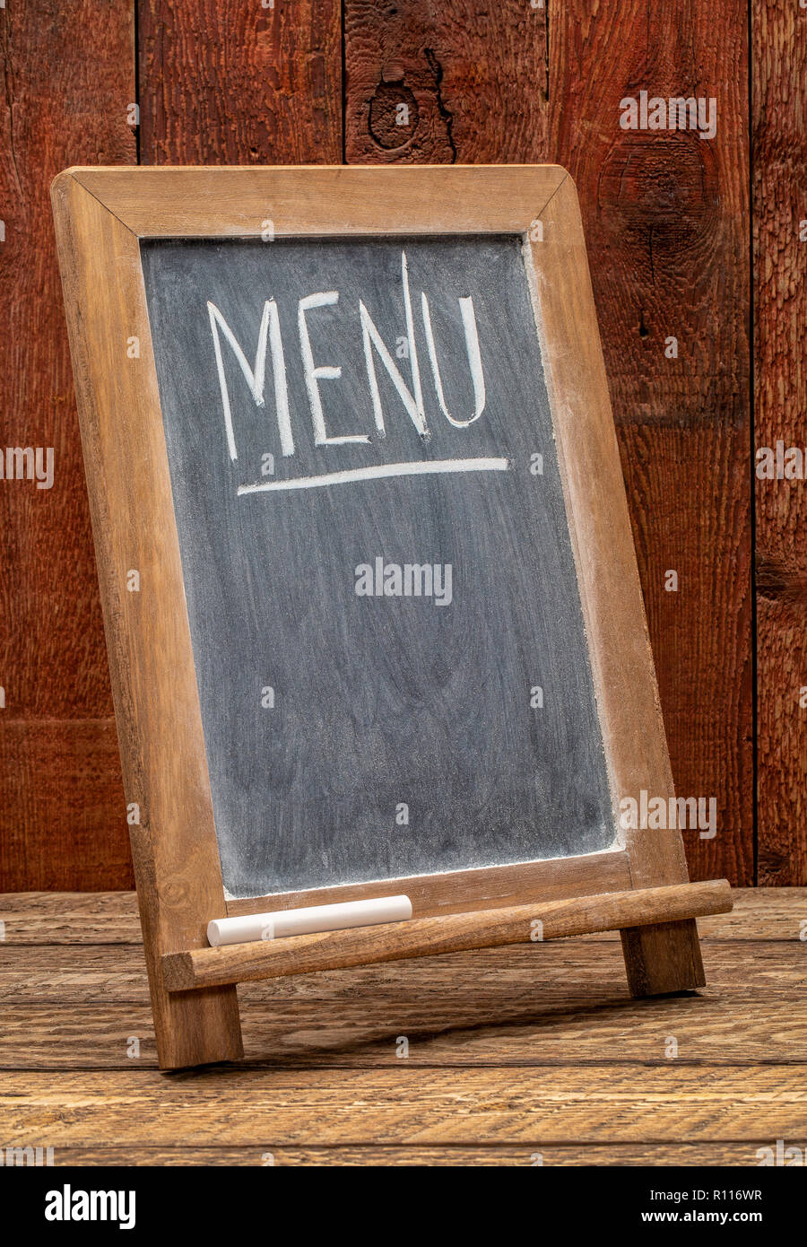 menu word in white chalk handwriting on a blackboard, copy space below ...