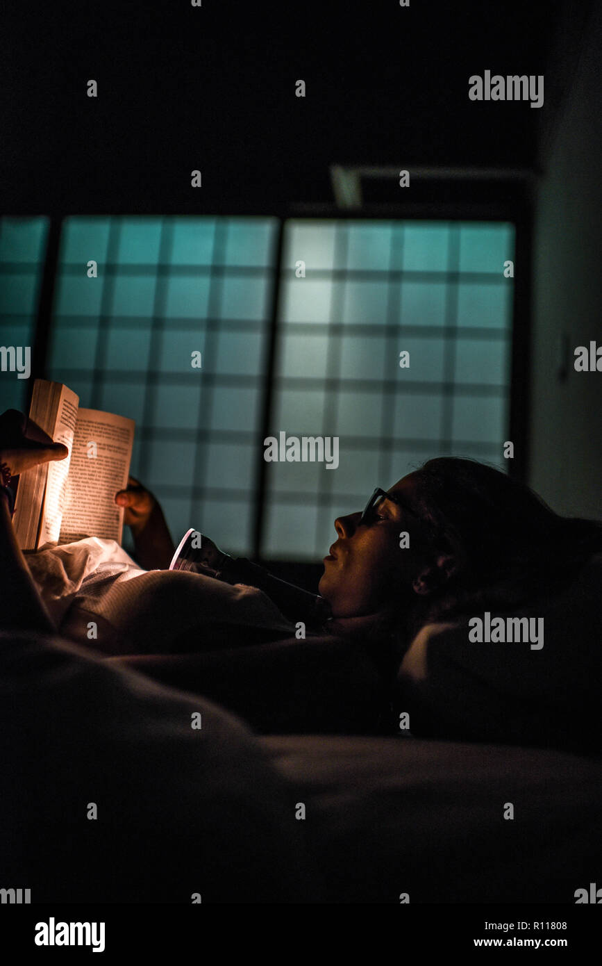 Woman reading book at night in Yochi-in temple room at Koyasan (Mount K ...