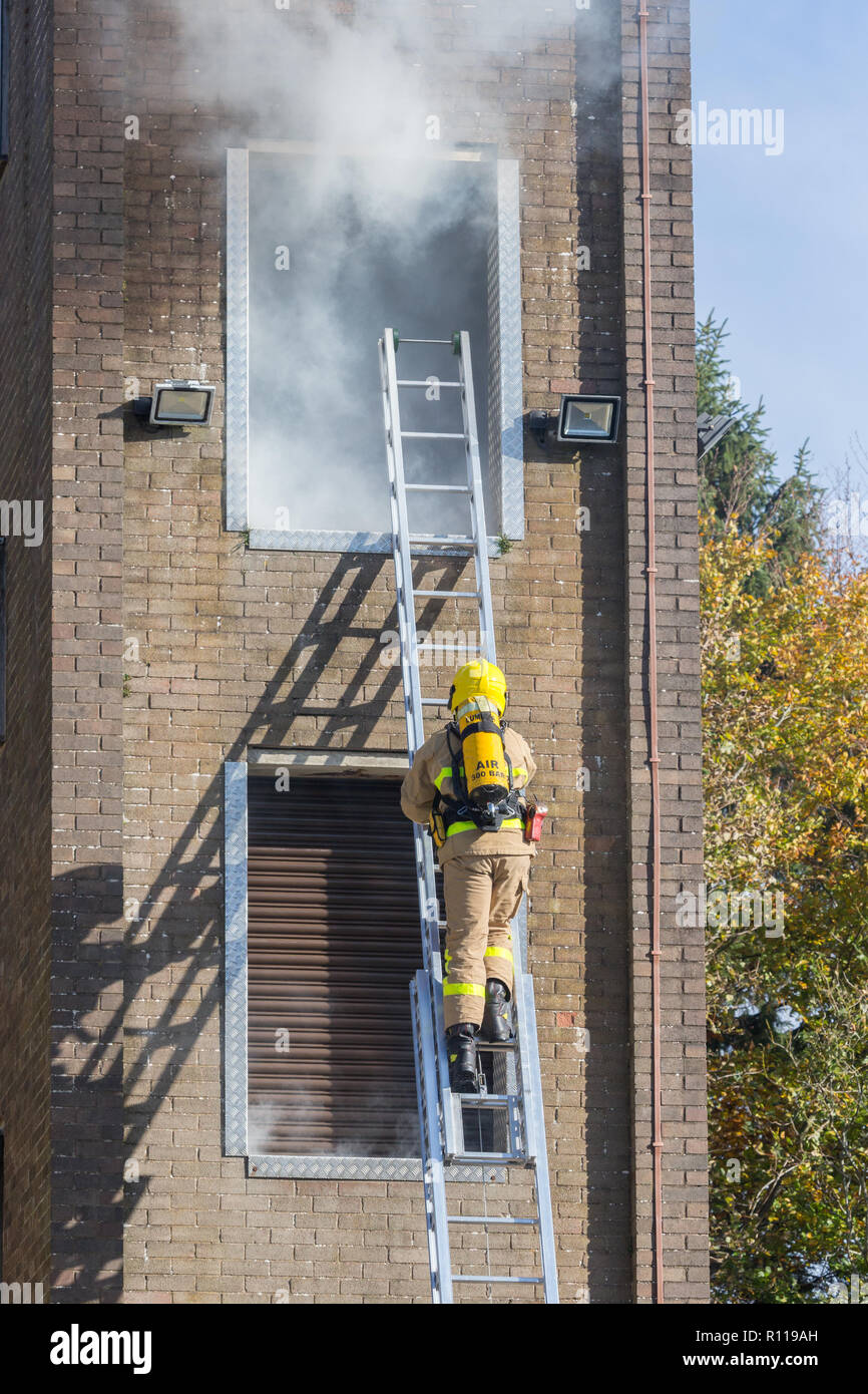 A firefighter using ladder access to enter a smoke filled tower during ...