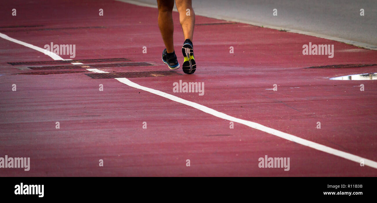 A man runs at the wet running track Stock Photo - Alamy