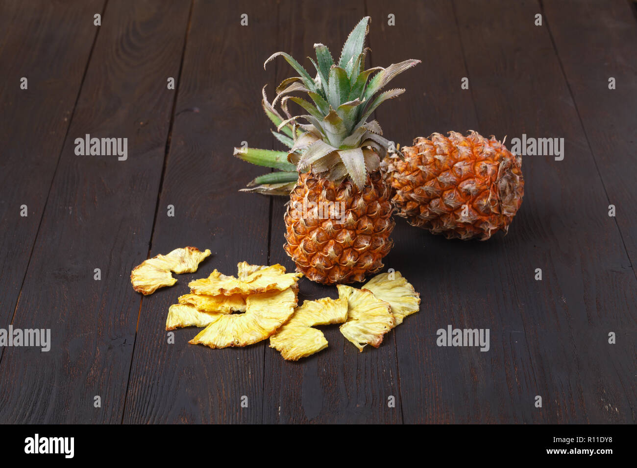 Dried dehydrated deep fried pineapple chips in a wooden table Stock ...