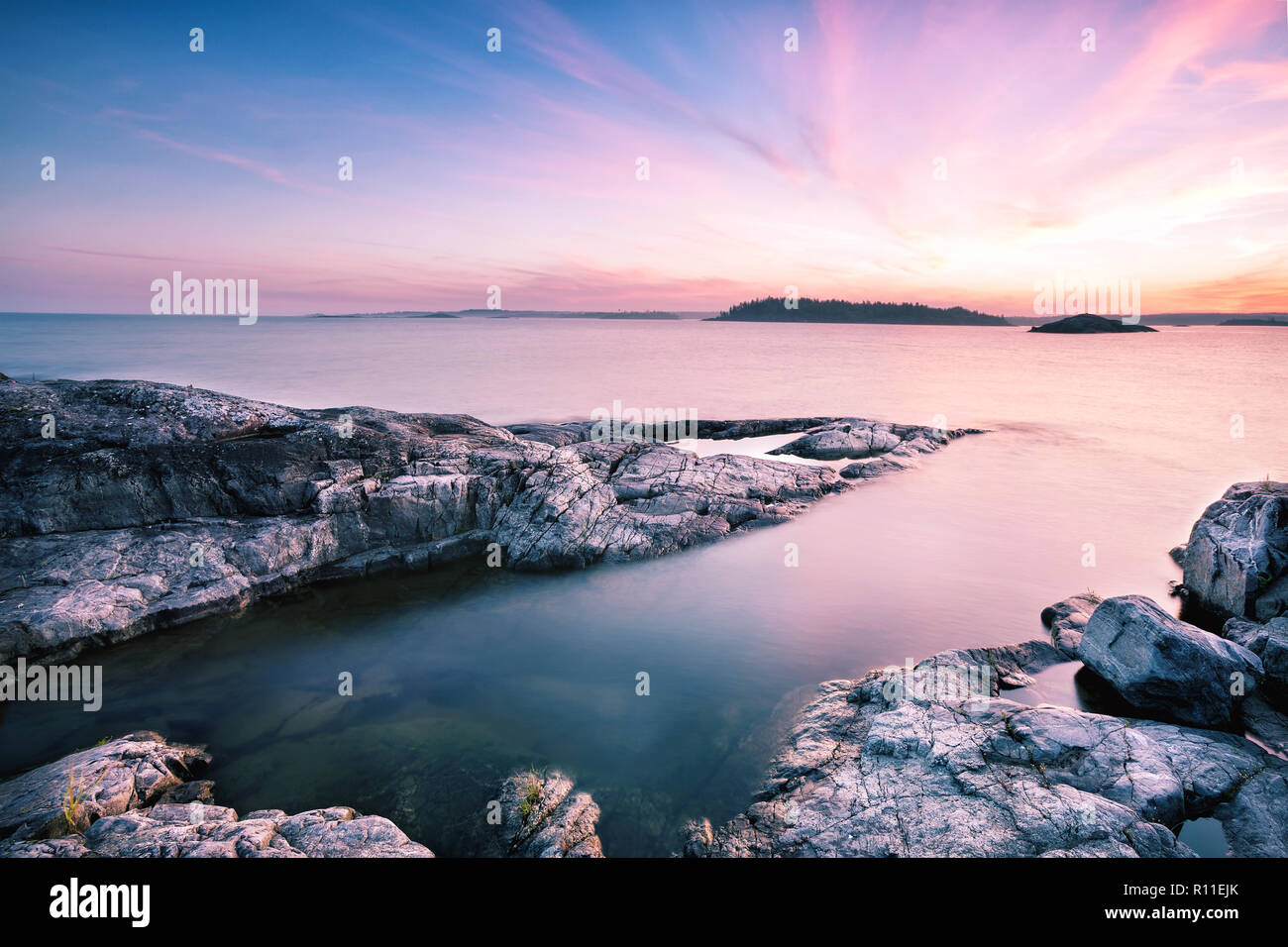 Textured stone island under dawn sky Stock Photo - Alamy
