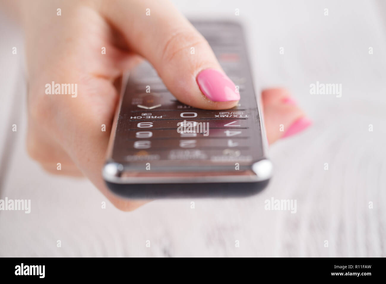 Hand pressing remote control Stock Photo - Alamy