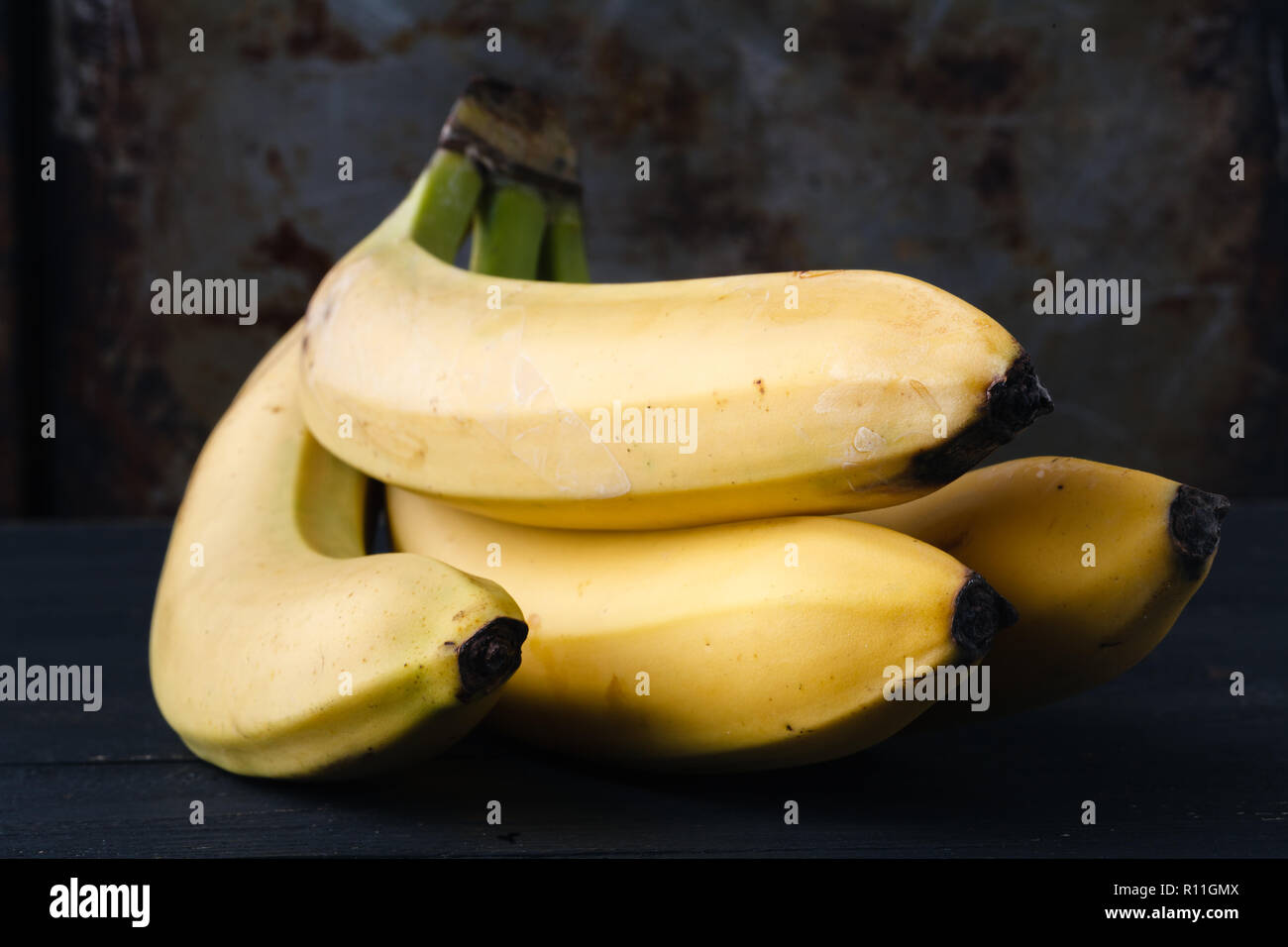 Yellow ripe bananas on rustic table Stock Photo - Alamy