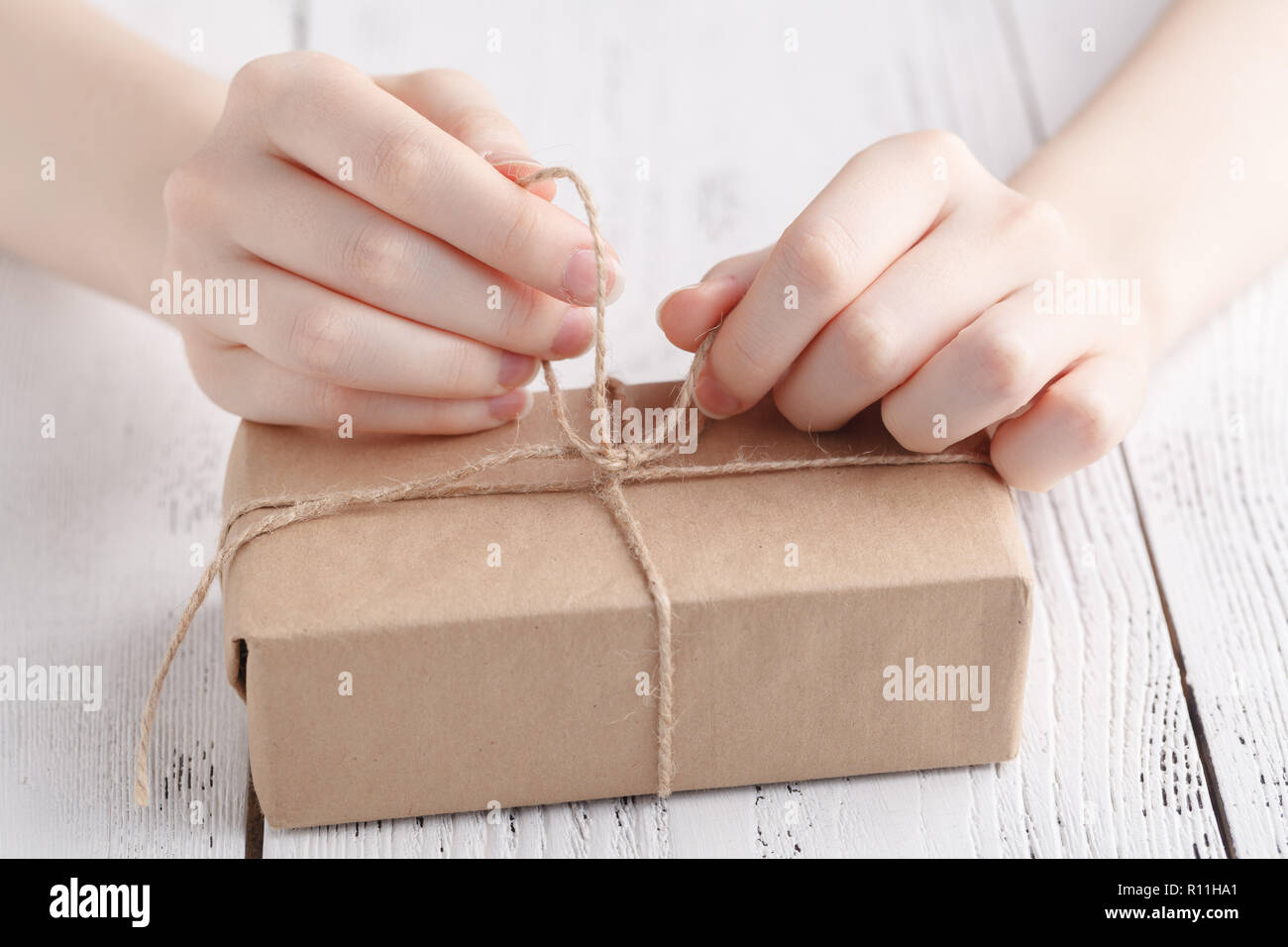 Packing gift in craft papper with twine Stock Photo - Alamy