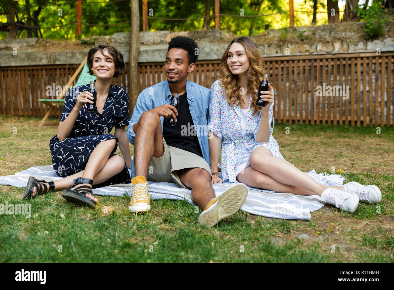 Image of a happy young multiethnic friends holding soda drinking in ...