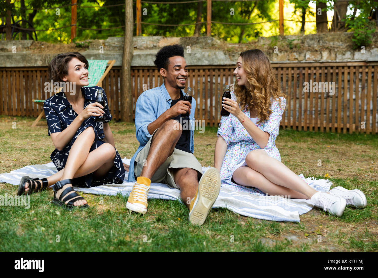 Image of a happy young multiethnic friends holding soda drinking in ...