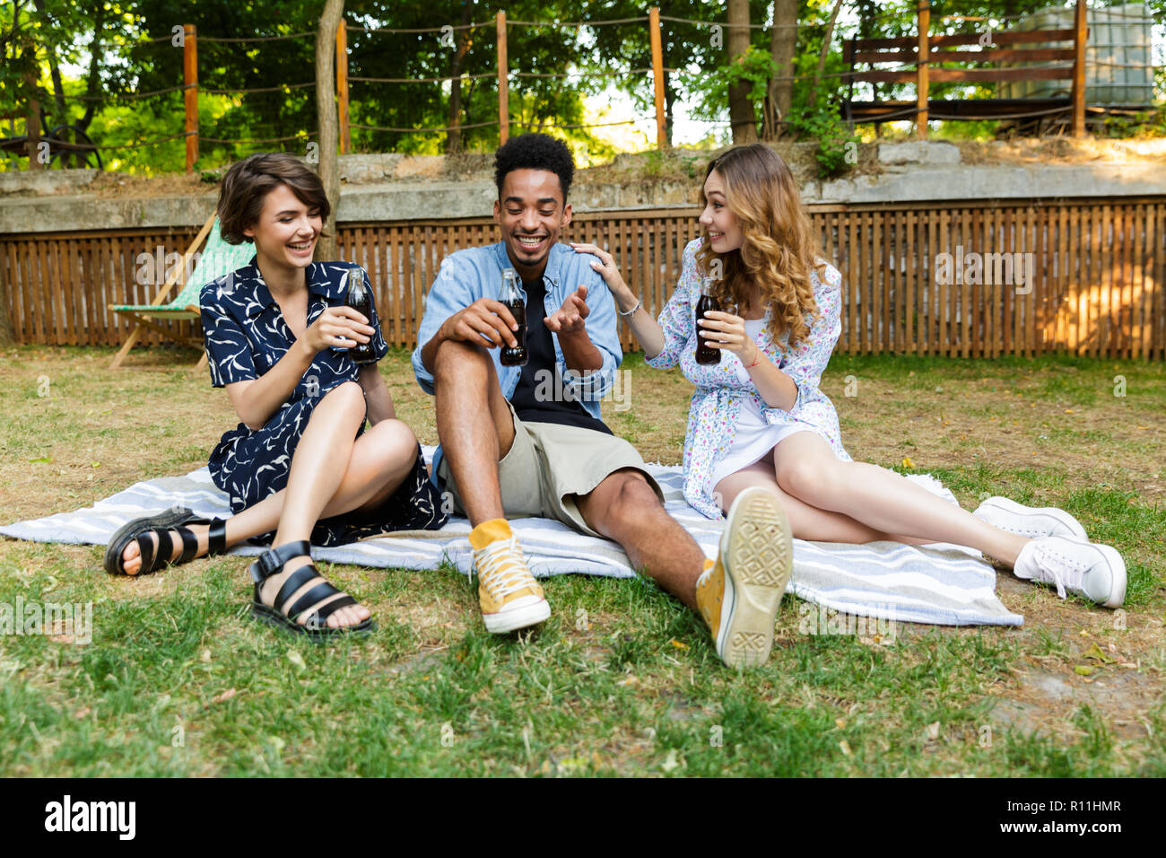 Image of a happy young multiethnic friends holding soda drinking in ...