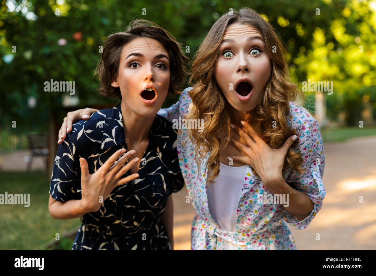 Image of a shocked young friends standing posing in park outdoors Stock ...