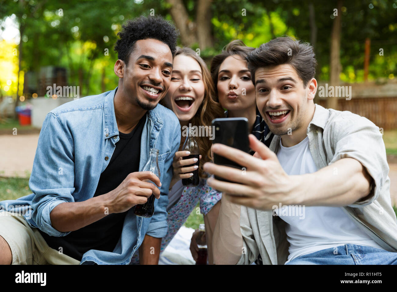 Image of excited cheerful young friends outdoors in park having fun ...