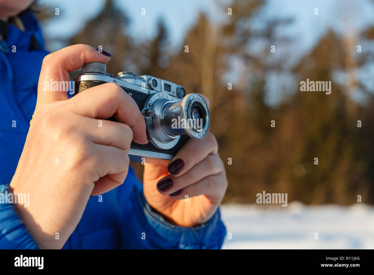Vintage camera in hand, outdoor winter with sky Stock Photo - Alamy