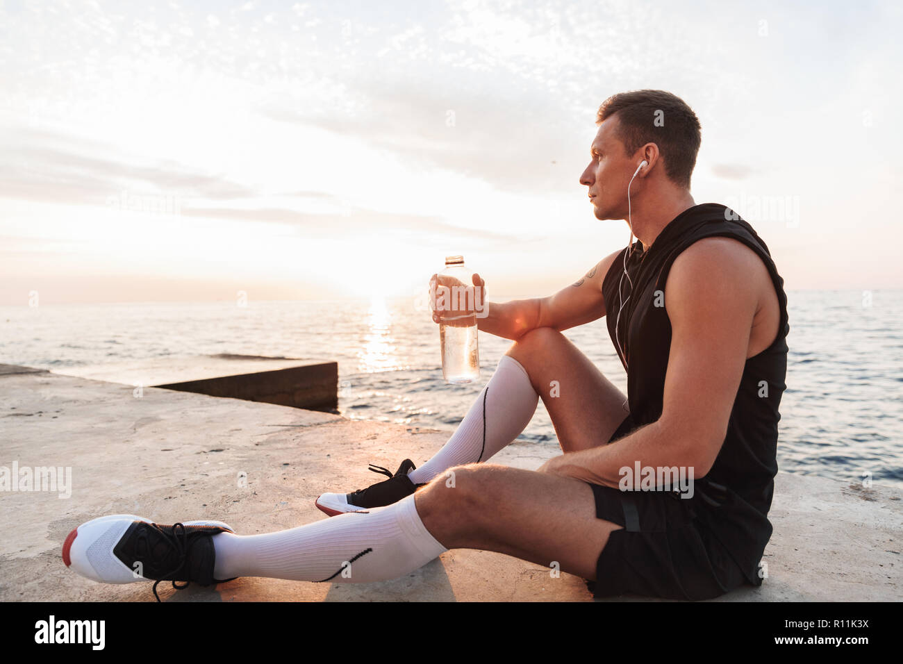 Picture of handsome strong young sportsman outdoors at the beach ...
