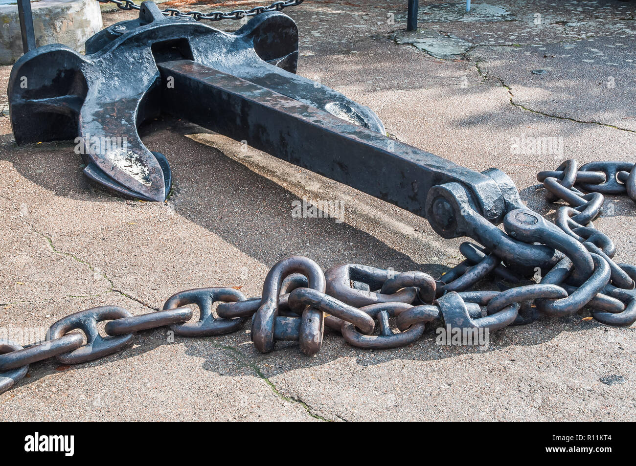 Heavy iron metal ship anchor with chain on gray asphalt Stock Photo - Alamy