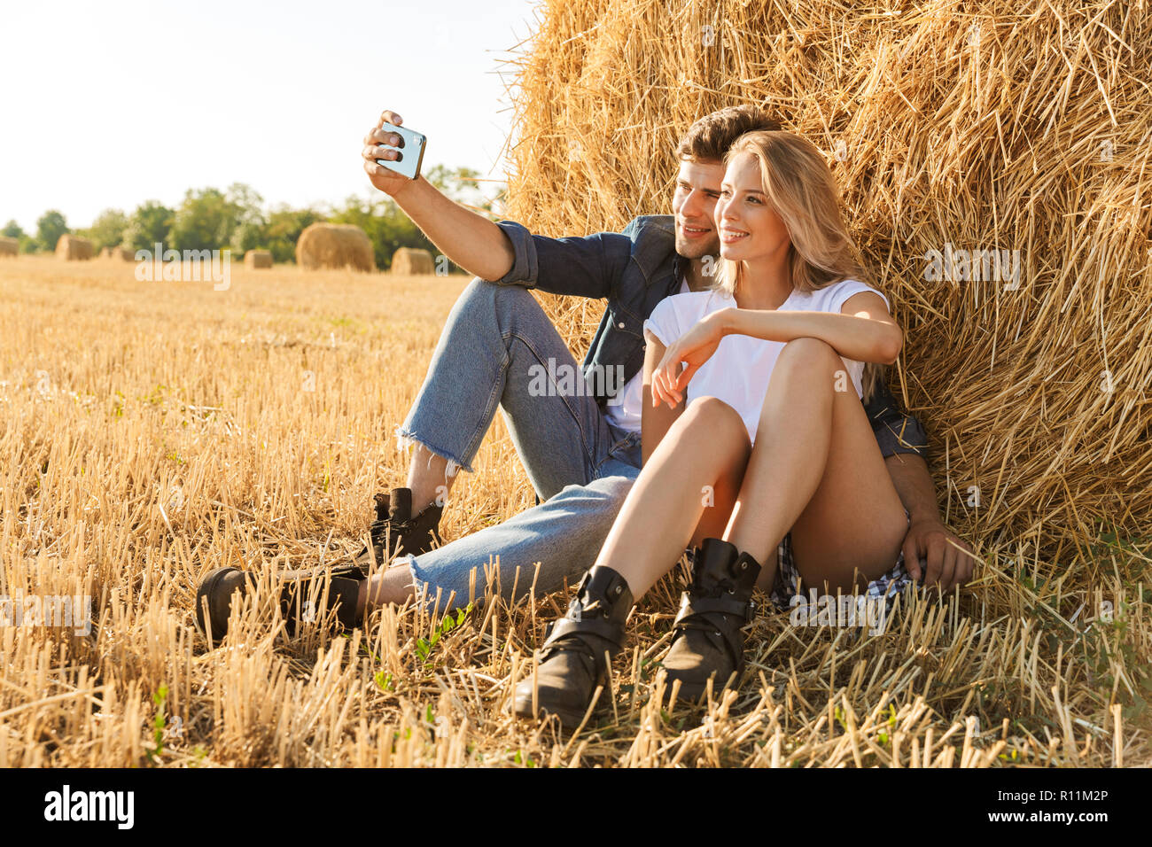 Photo of romantic couple man and woman taking selfie while sitting ...