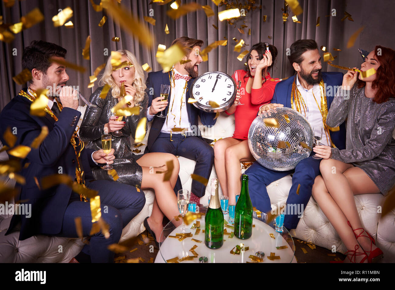 Group of people partying among confetti Stock Photo - Alamy