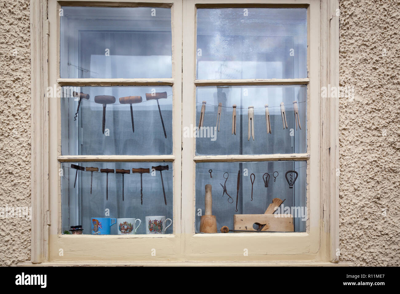 Collection of wooden pegs, augers, cork screws etc hanging in a house ...