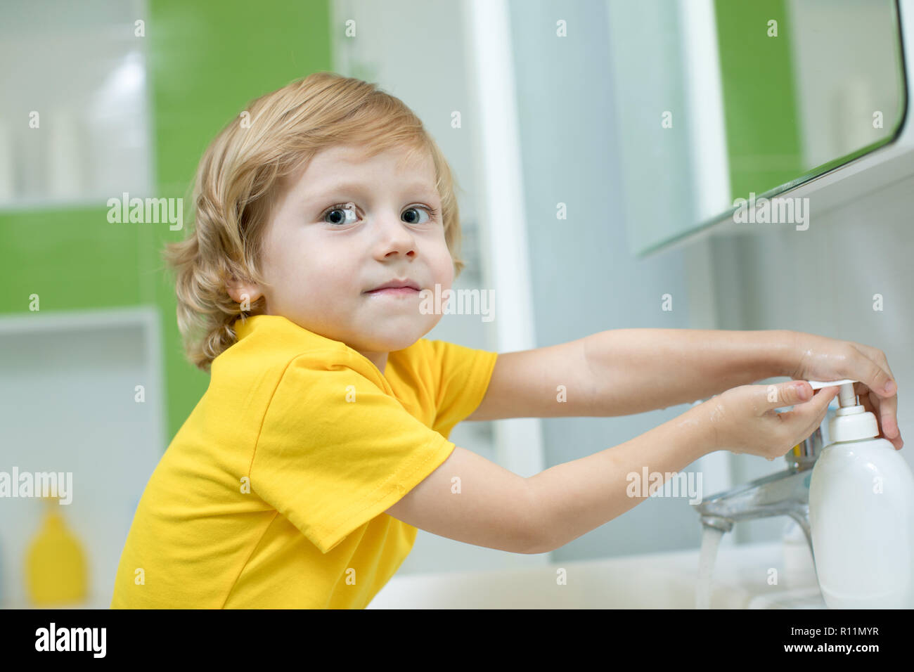 Little kid boy washing his hands with soap in the bathroom Stock Photo ...