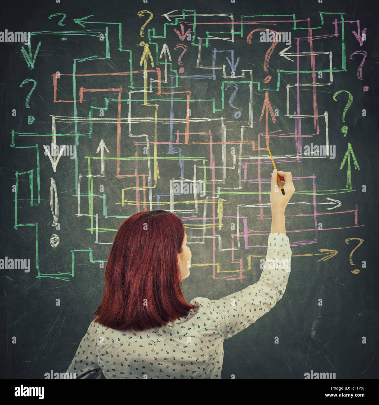 Rear view of a young businesswoman drawing different colorful arrows ...