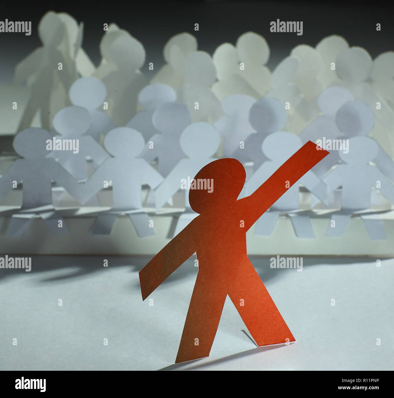 leader standing in front of a group of paper doll Stock Photo - Alamy