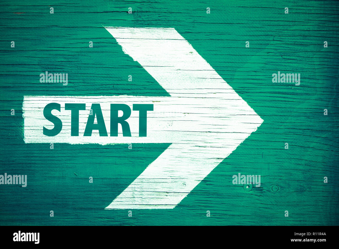 Start text written on white directional arrow pointing right painted on ...