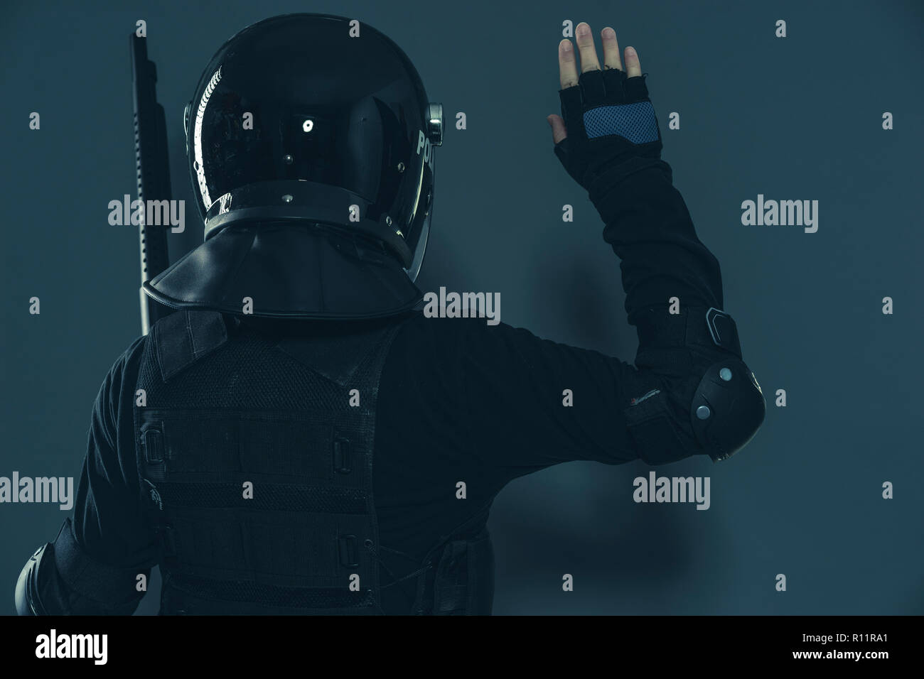 riot police signaling to colleagues with their hands. armed man with ...