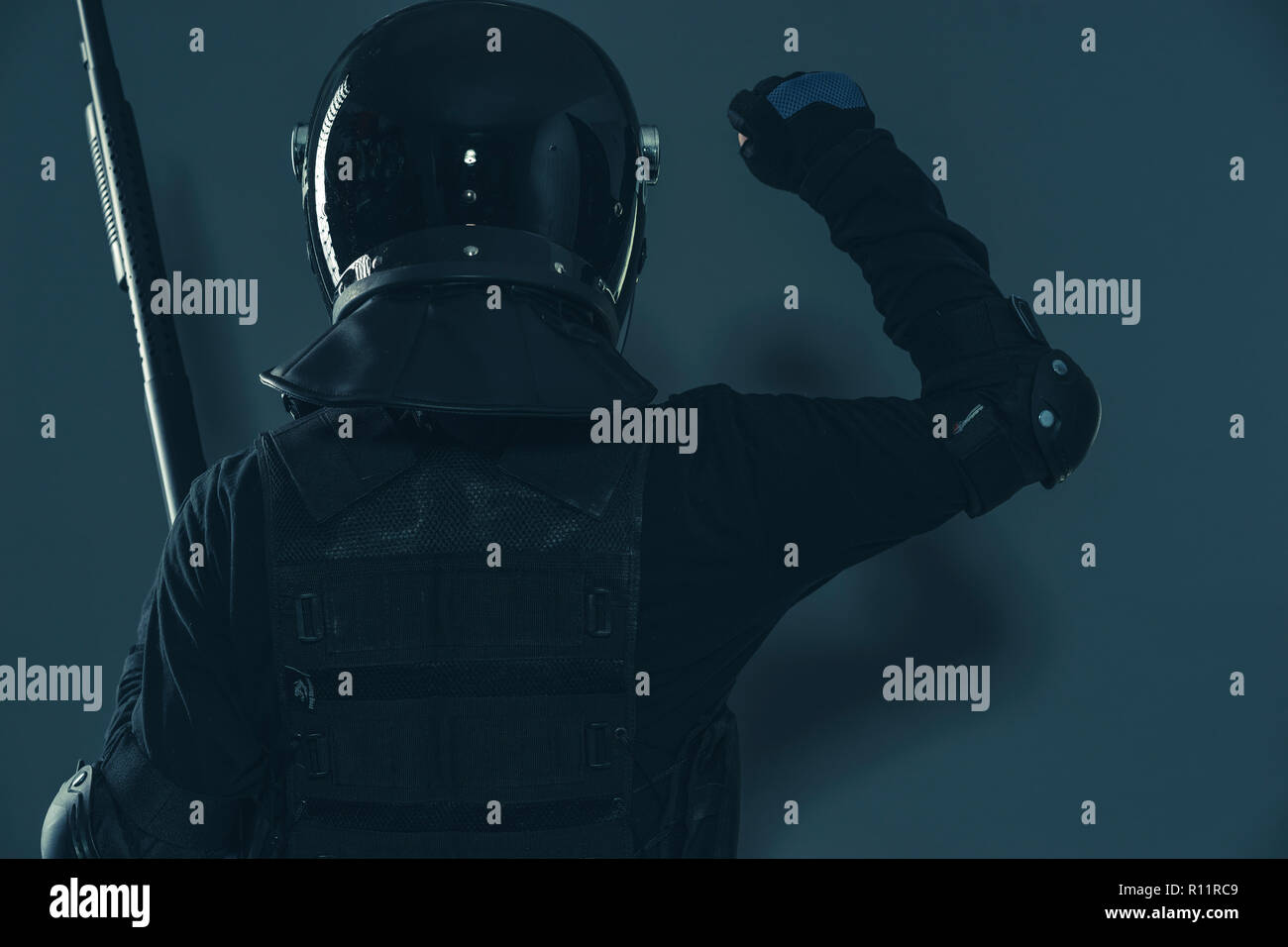 riot police signaling to colleagues with their hands. armed man with ...