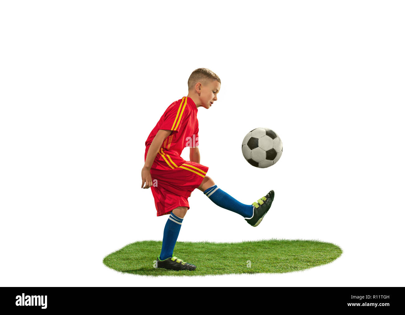 Young boy with soccer ball doing flying kick, isolated on white ...