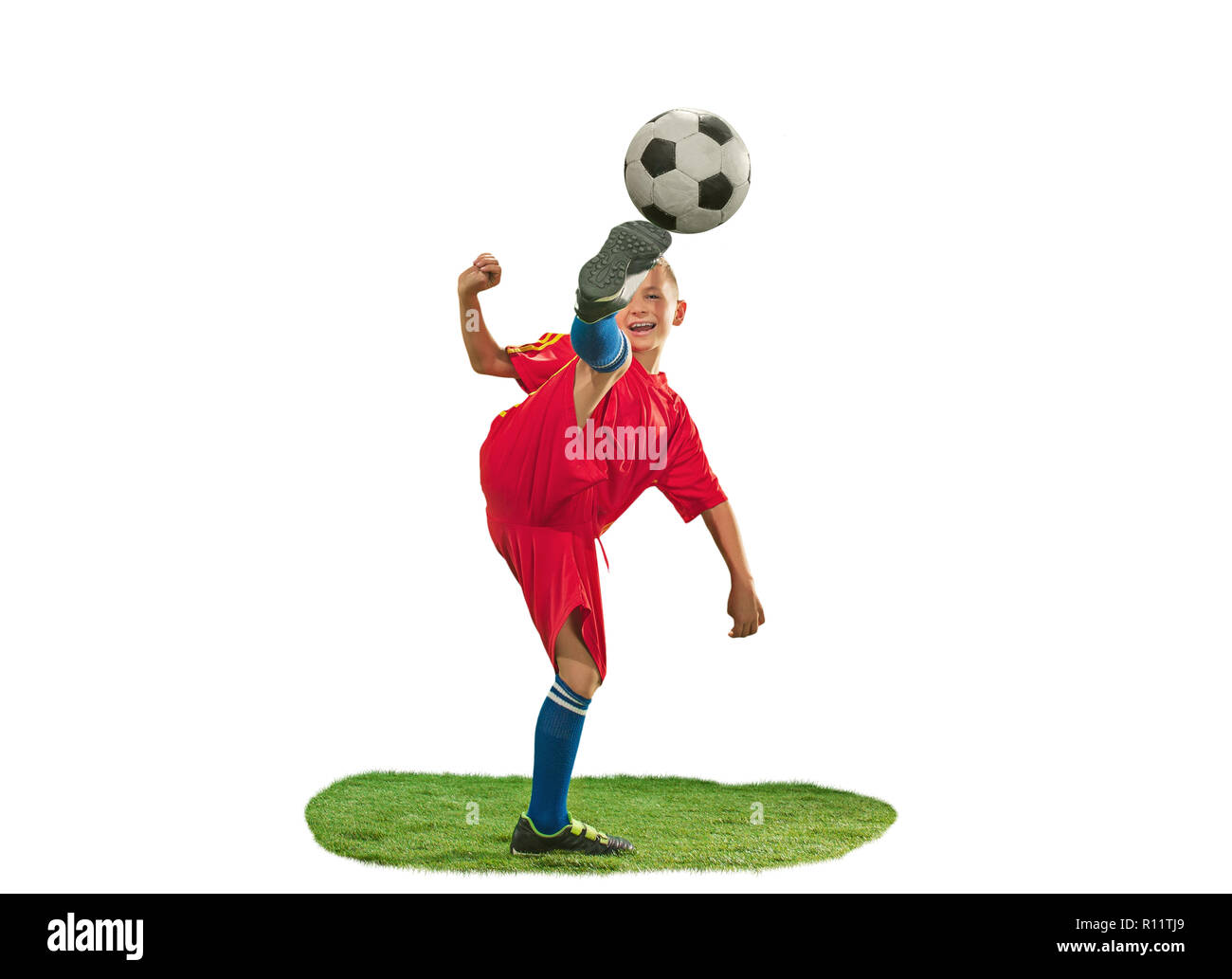 Young boy with soccer ball doing flying kick, isolated on white ...