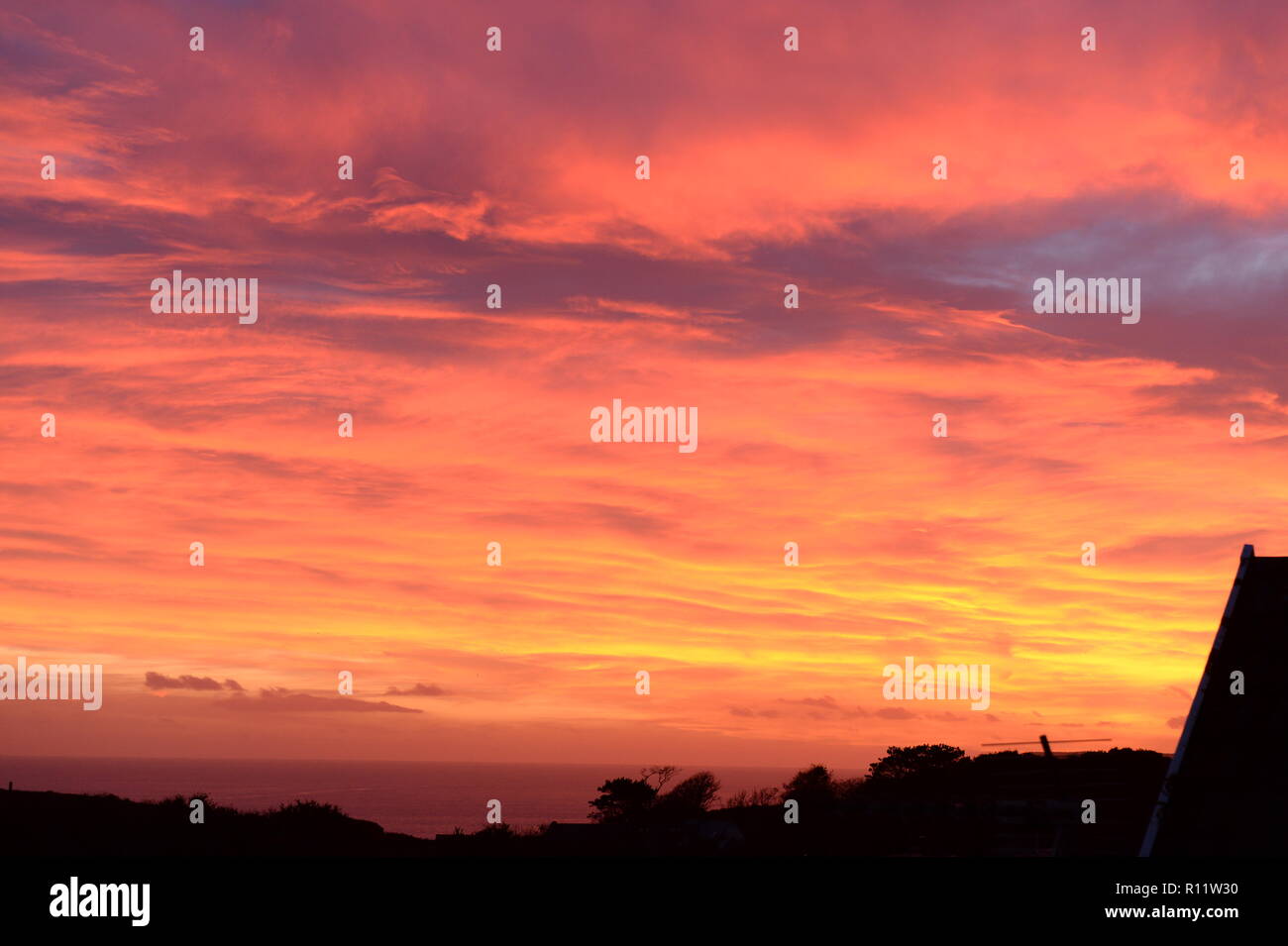 Sunset at Mumbles. A Setting Sun disappears below the horizon causing ...