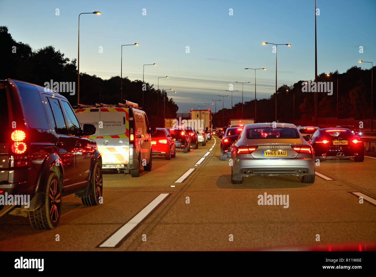 Busy rush hour traffic on the M25 motorway at dusk from a drivers point ...