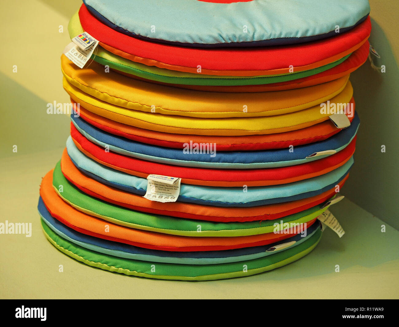 brightly coloured stack of random seat cushions in contrasting vibrant ...