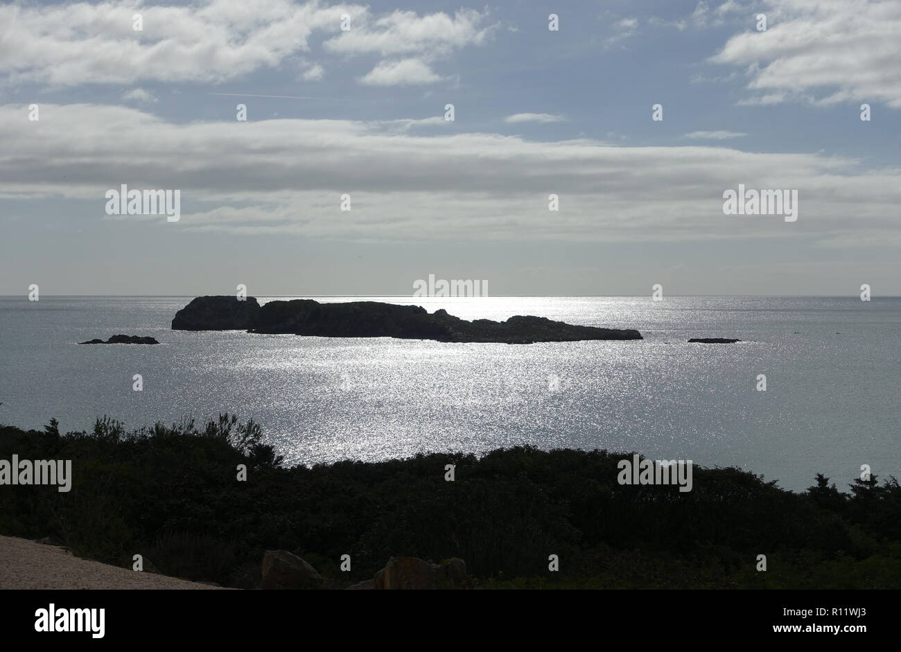 Small island highlighted by sun on cloudy day Stock Photo - Alamy