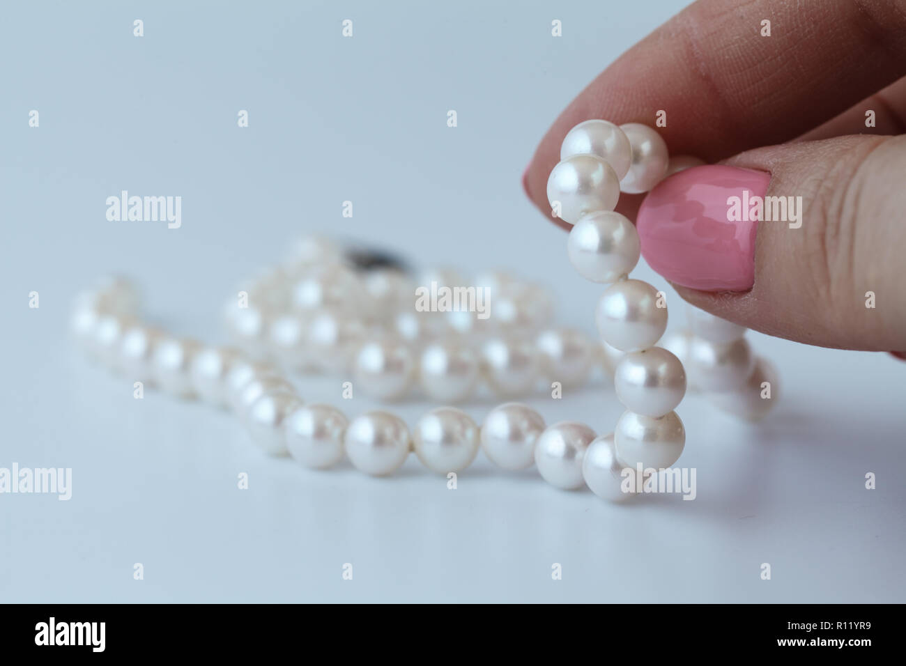 White pearl in female hand Stock Photo - Alamy