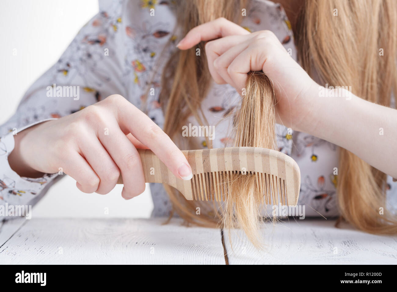 young beautiful woman combing her hair in living room Stock Photo - Alamy