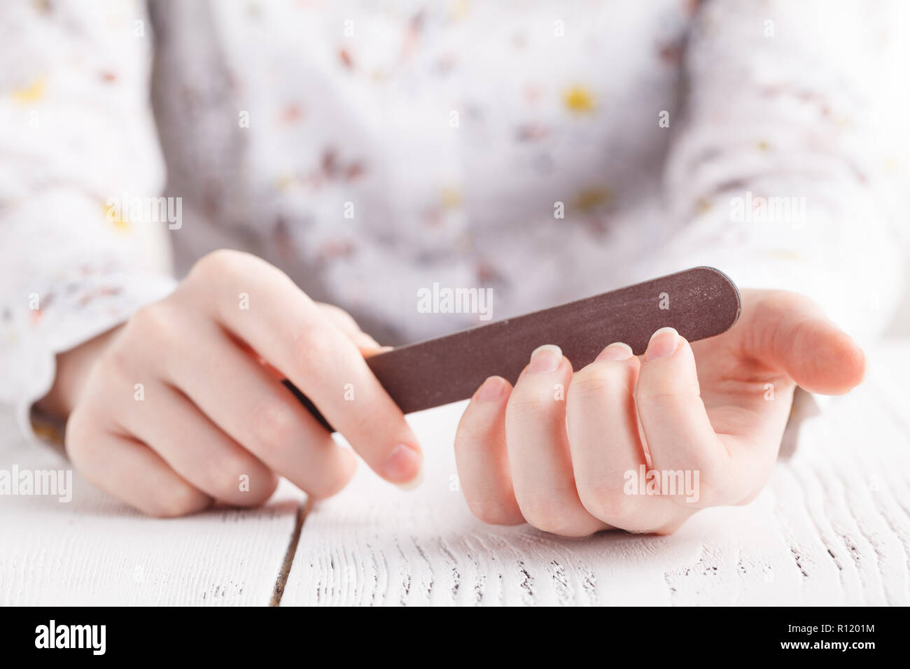 Hand filing nails with nail file on the white background Stock Photo ...