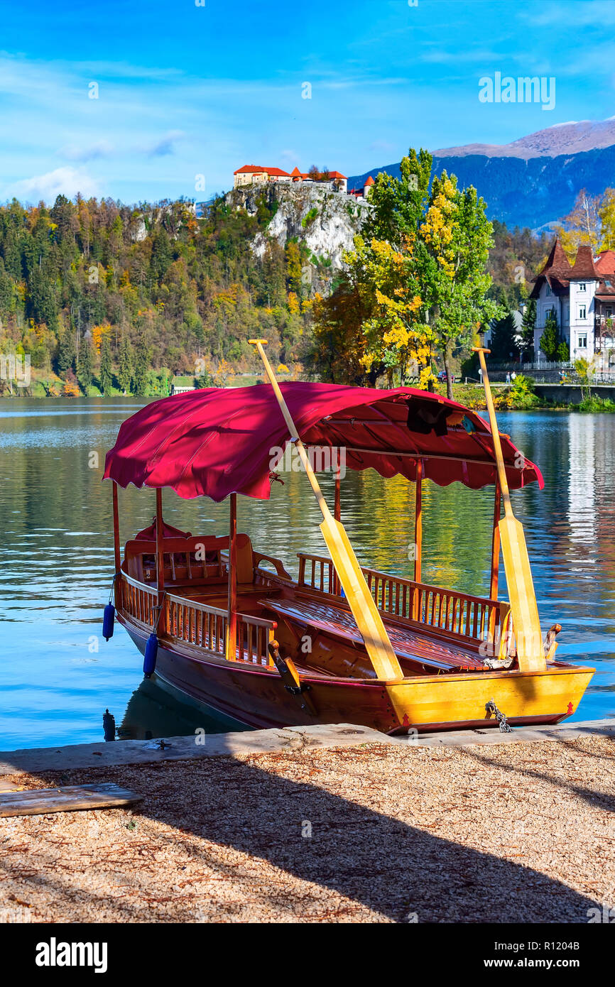 Pletna tourist boat, castle and autumn colorful trees background in ...
