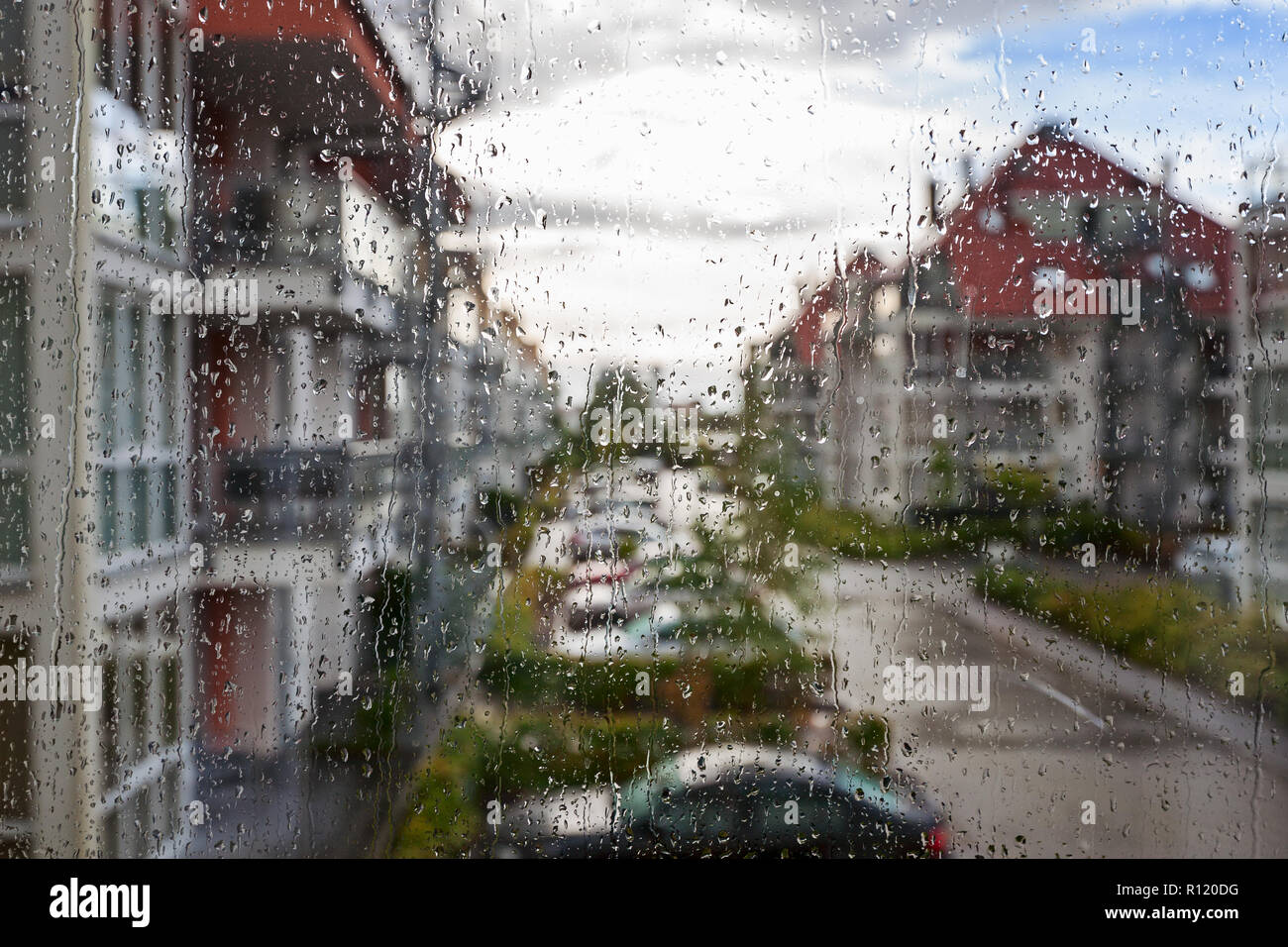 Wet window with rain drops and blurred street bokeh. Home window after ...